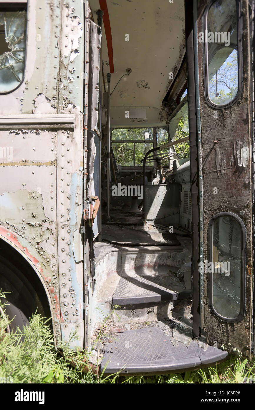 Worn drivers seat and steering wheel in front of abandoned commuter bus ...