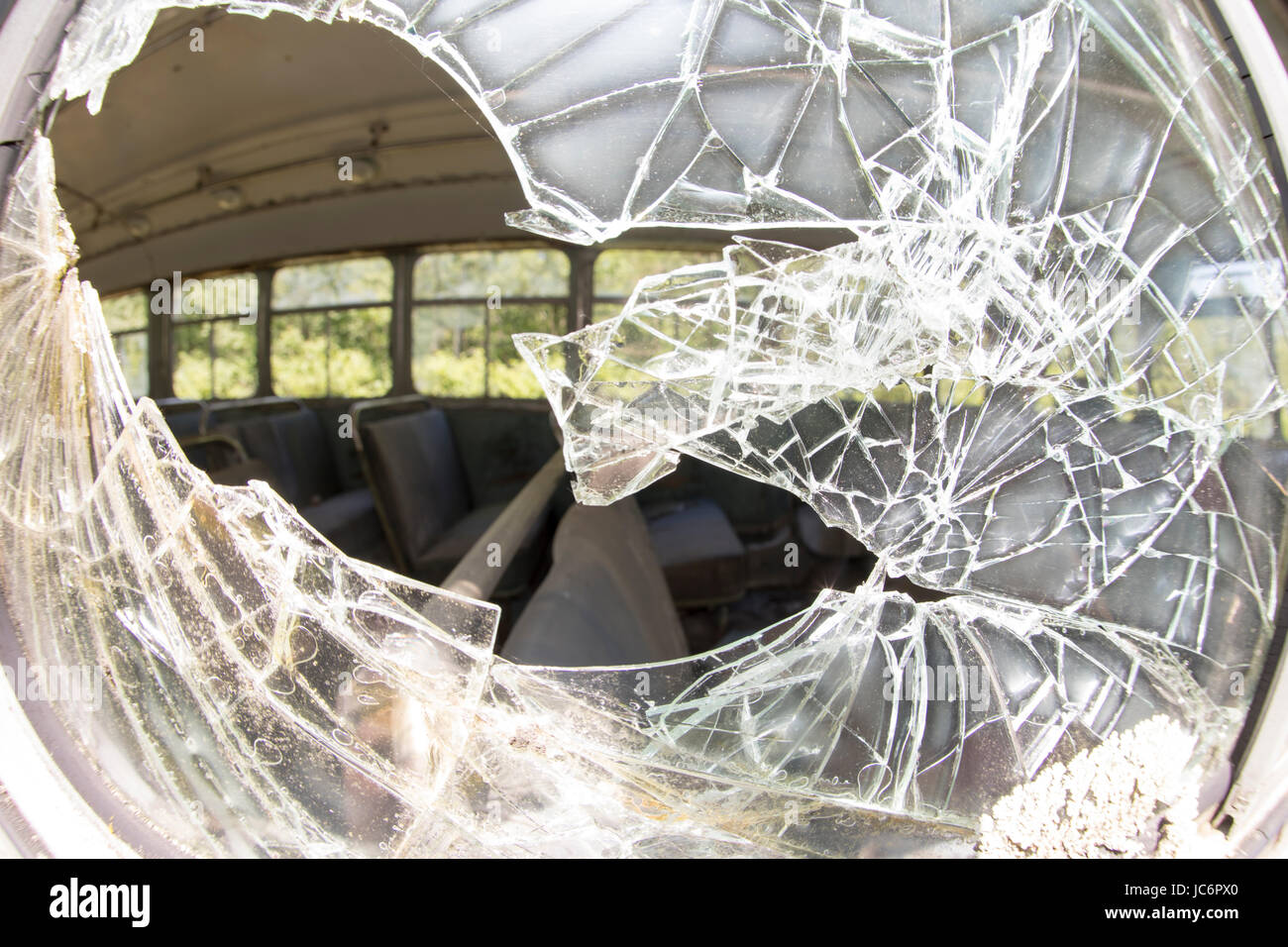 Old damaged public bus through broken shards of safety glass Stock ...