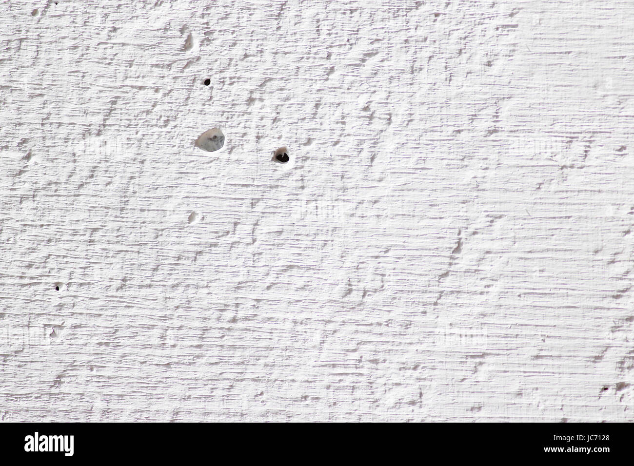 clear white wall with smooth plaster with small holes on the surface ...