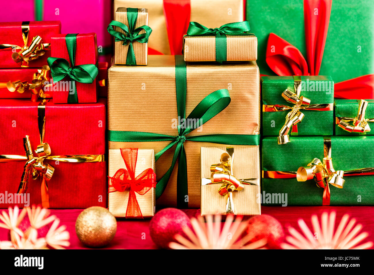 Three stacks of plain Christmas presents assorted by color. Red, gold ...