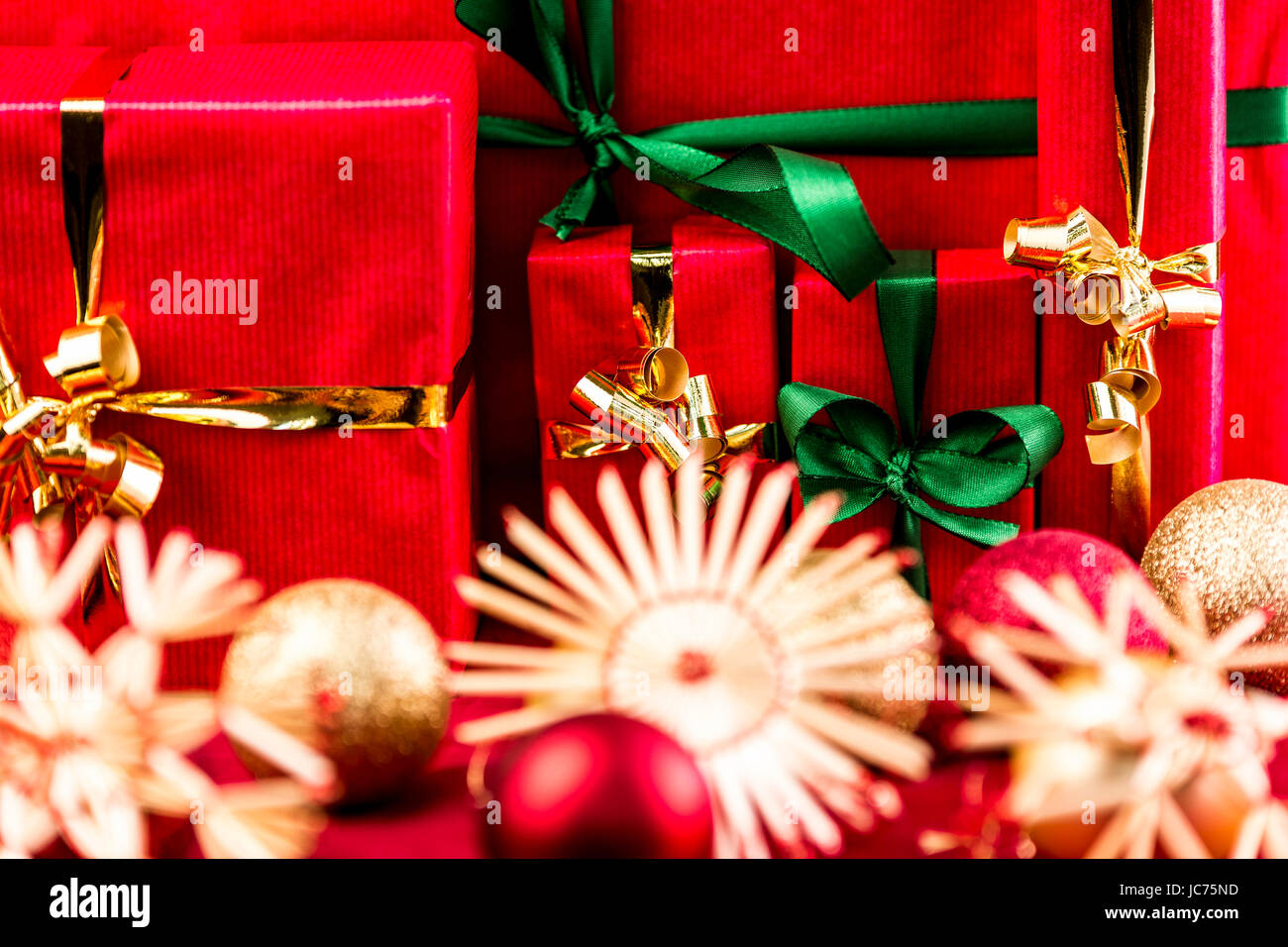 Christmas presents wrapped all in red. Green and golden bows. Blurred ...