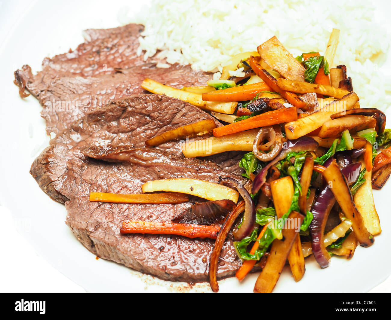 Seasond and fried steak with rice and vegetables on white plate Stock ...