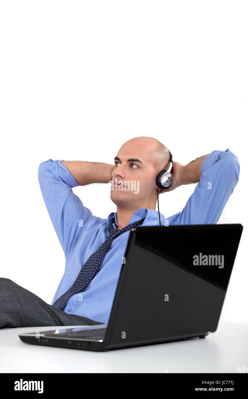 Office worker listening to music through headphones Stock Photo - Alamy