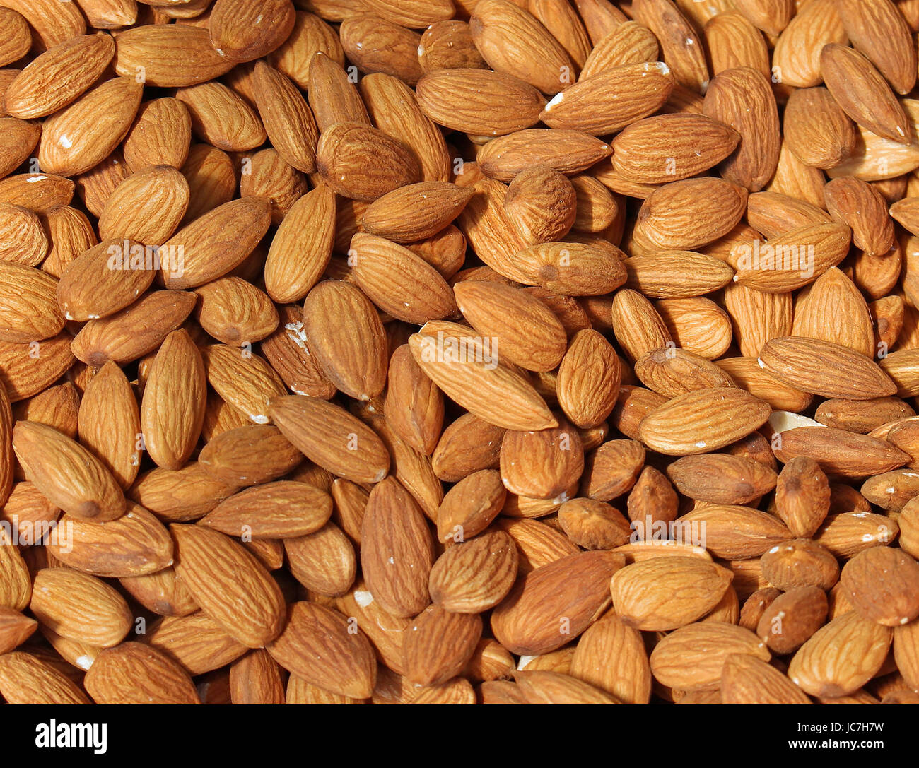 Big pile of raw almonds nuts background Stock Photo - Alamy