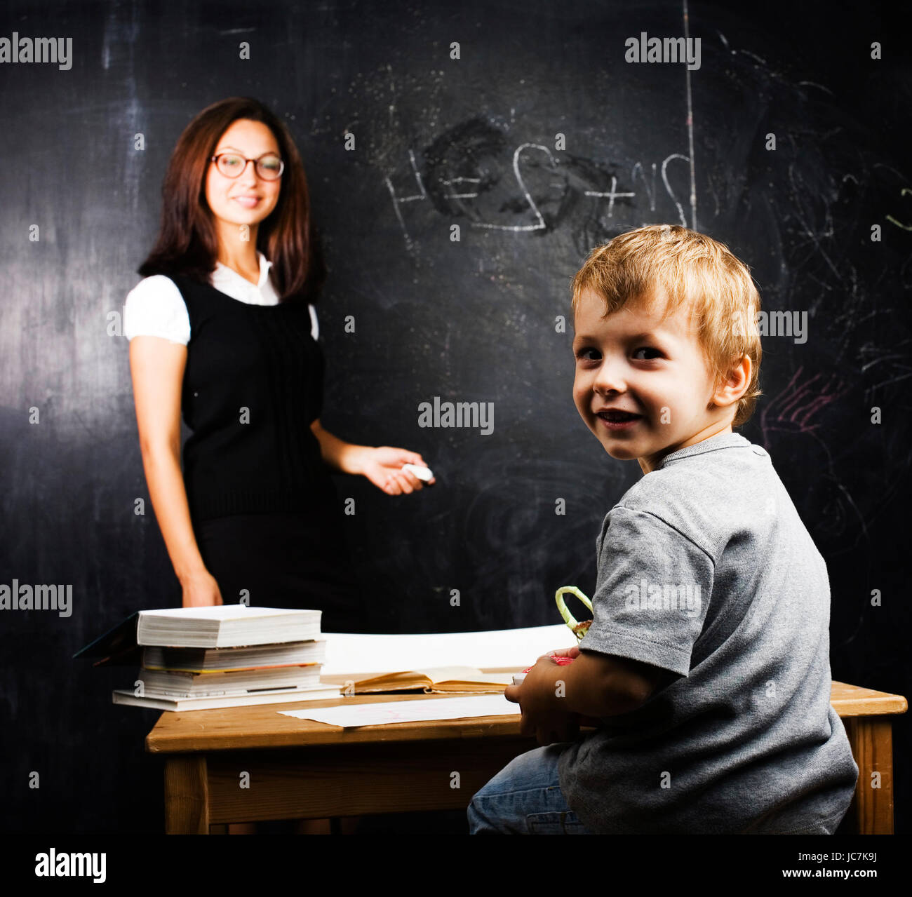 little cute boy with teacher in classroom Stock Photo - Alamy