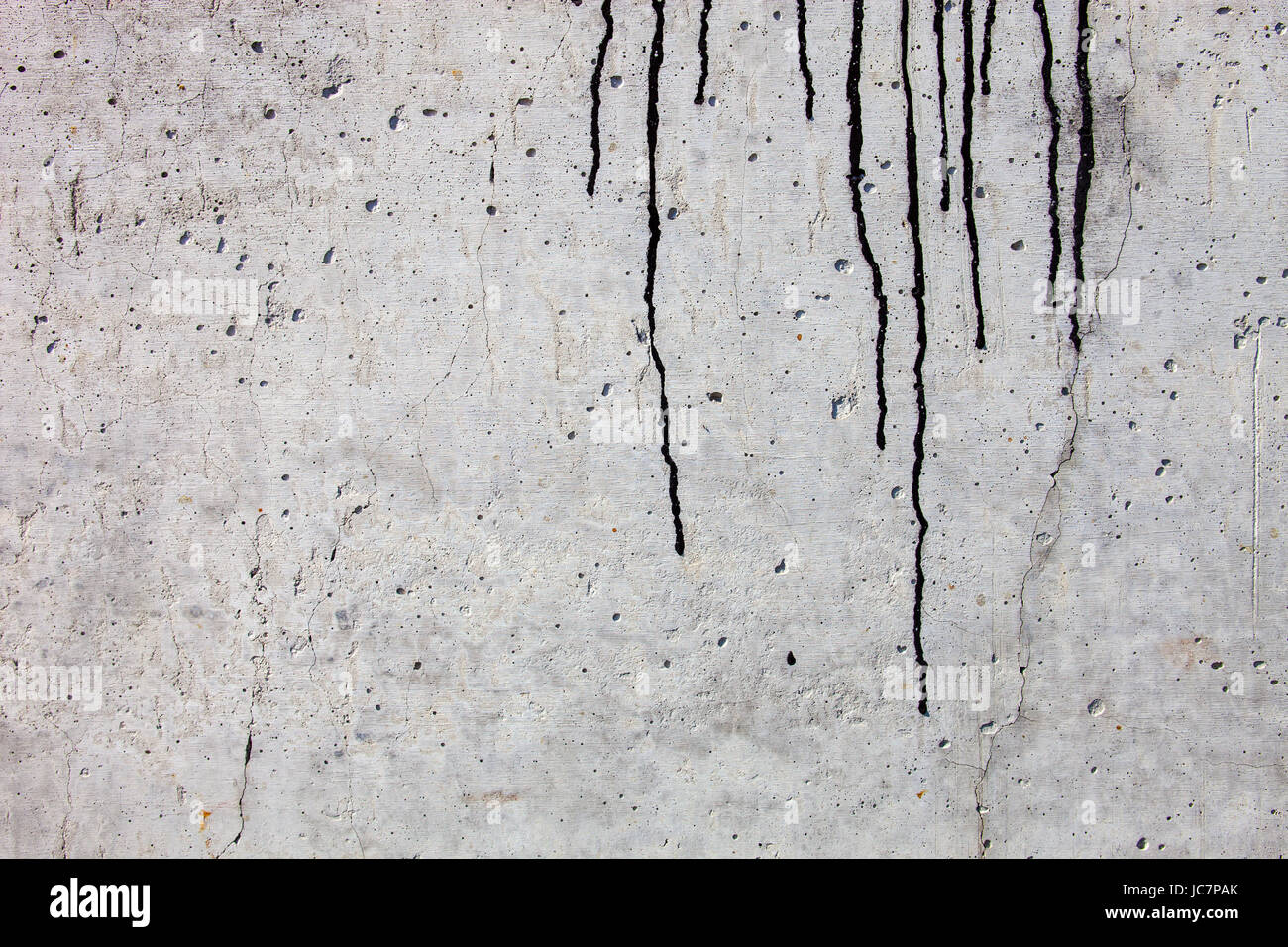 Grey concrete surface with black bitumen streaks and rich and various ...