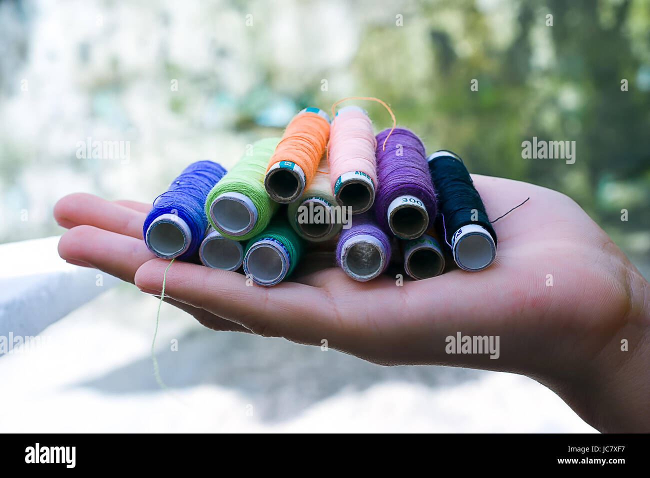 A human hand holding colorful threads Stock Photo - Alamy