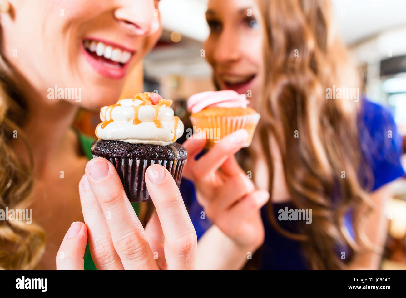 Friends having fun and eating muffins at bakery or pastry shop Stock ...