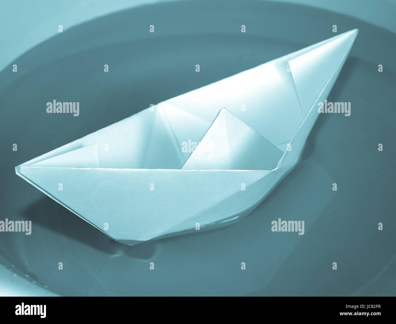 Toy paper boat over a blue water background - cool cyanotype Stock ...