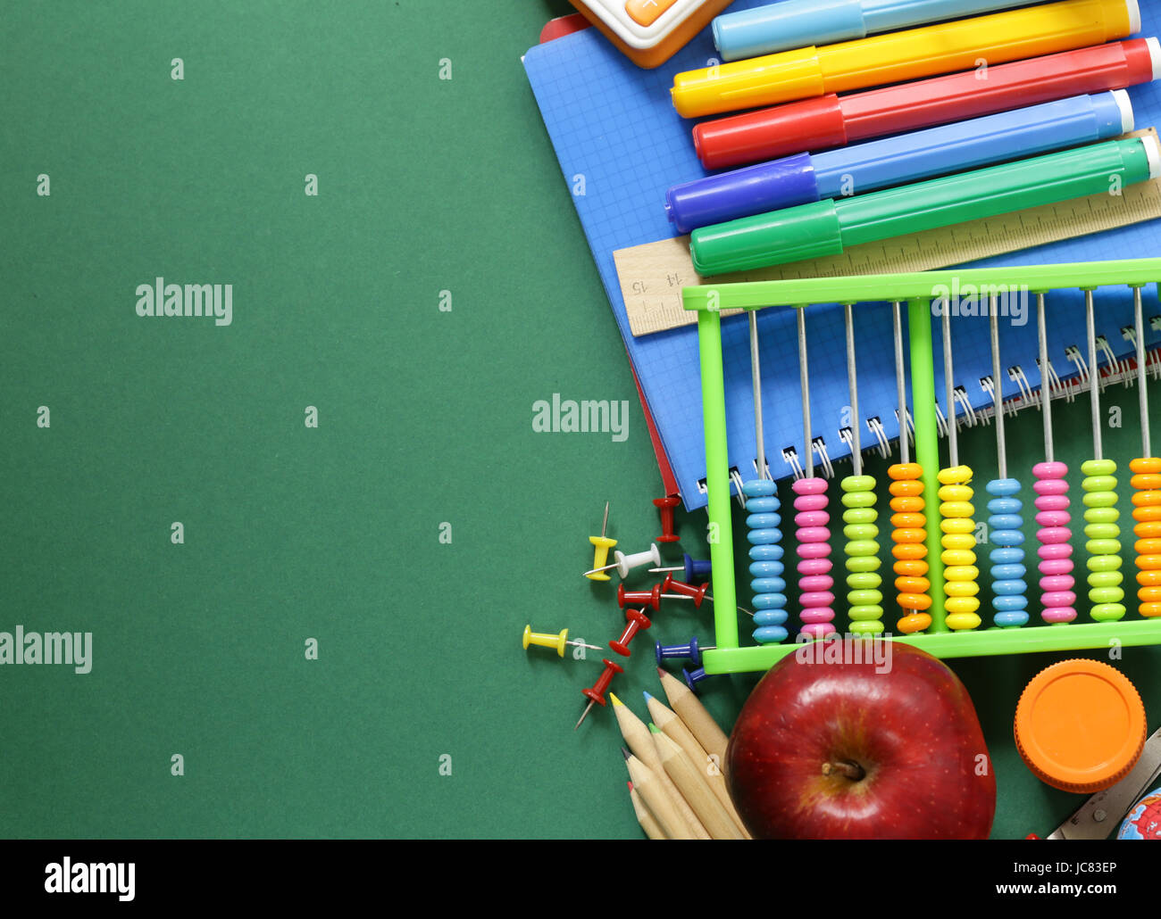 School supplies and apple on a green background Stock Photo - Alamy