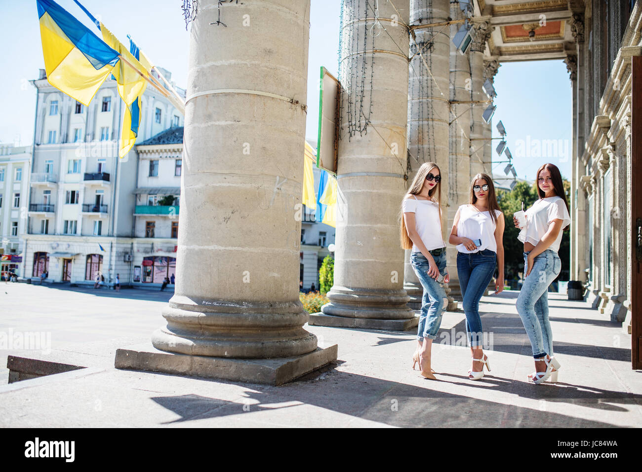 Three gorgeous girls standing by the columns on a sunny day Stock Photo ...