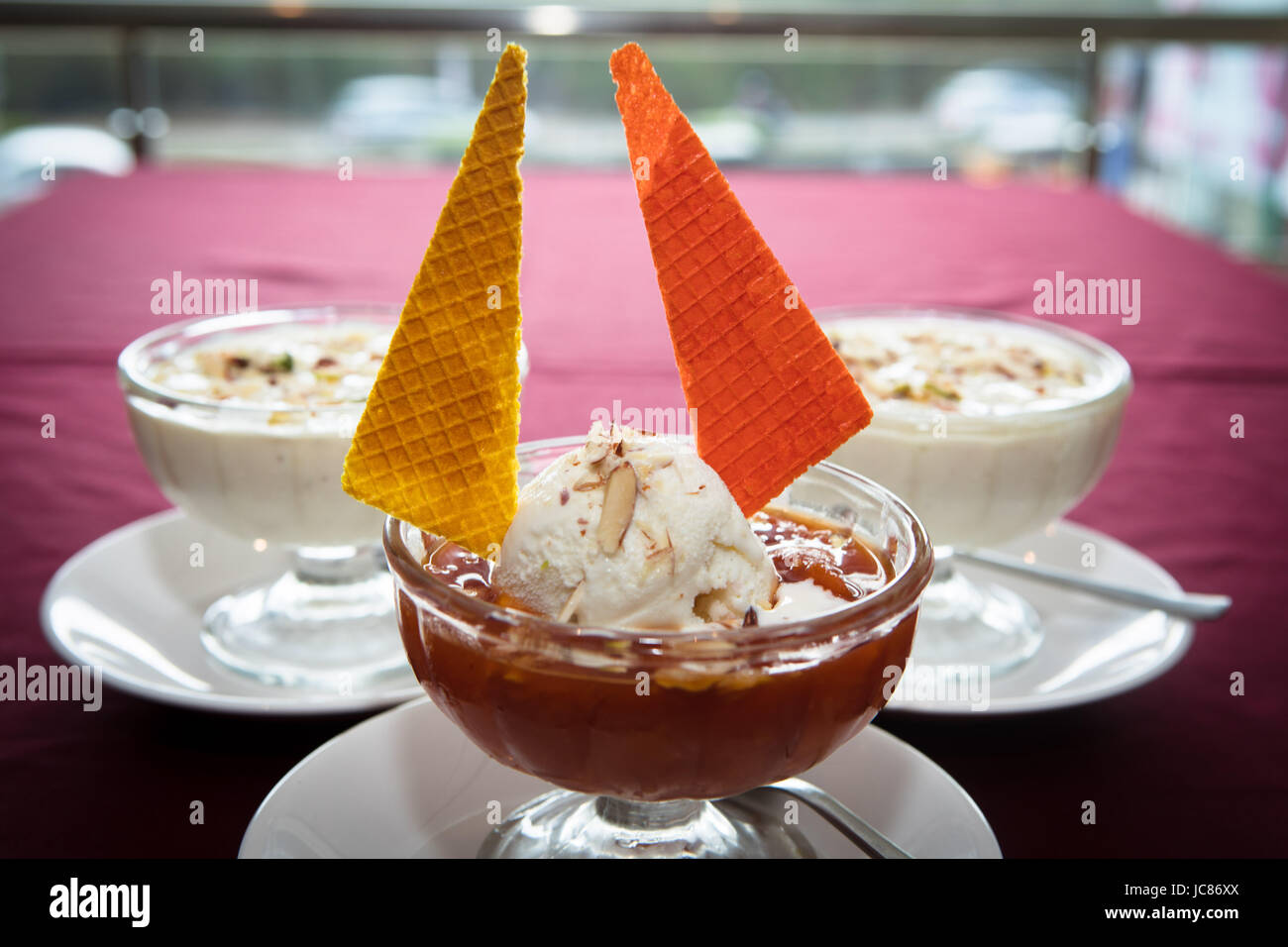 Qubani ka meetha with vanilla icecream in the foreground and rabri ...