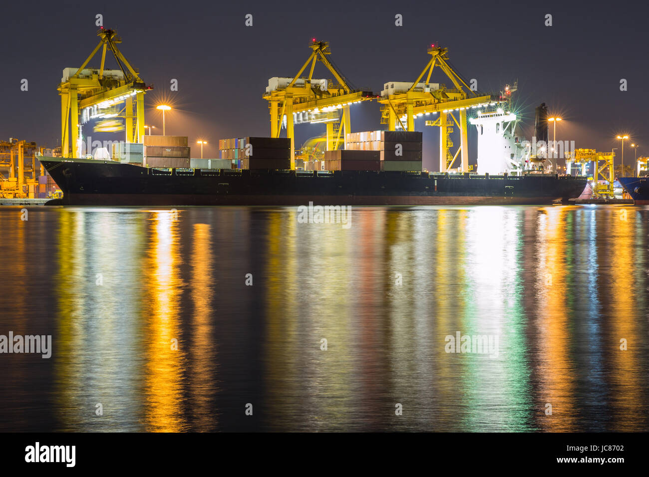 Container Cargo freight ship with working crane bridge in shipyard at ...