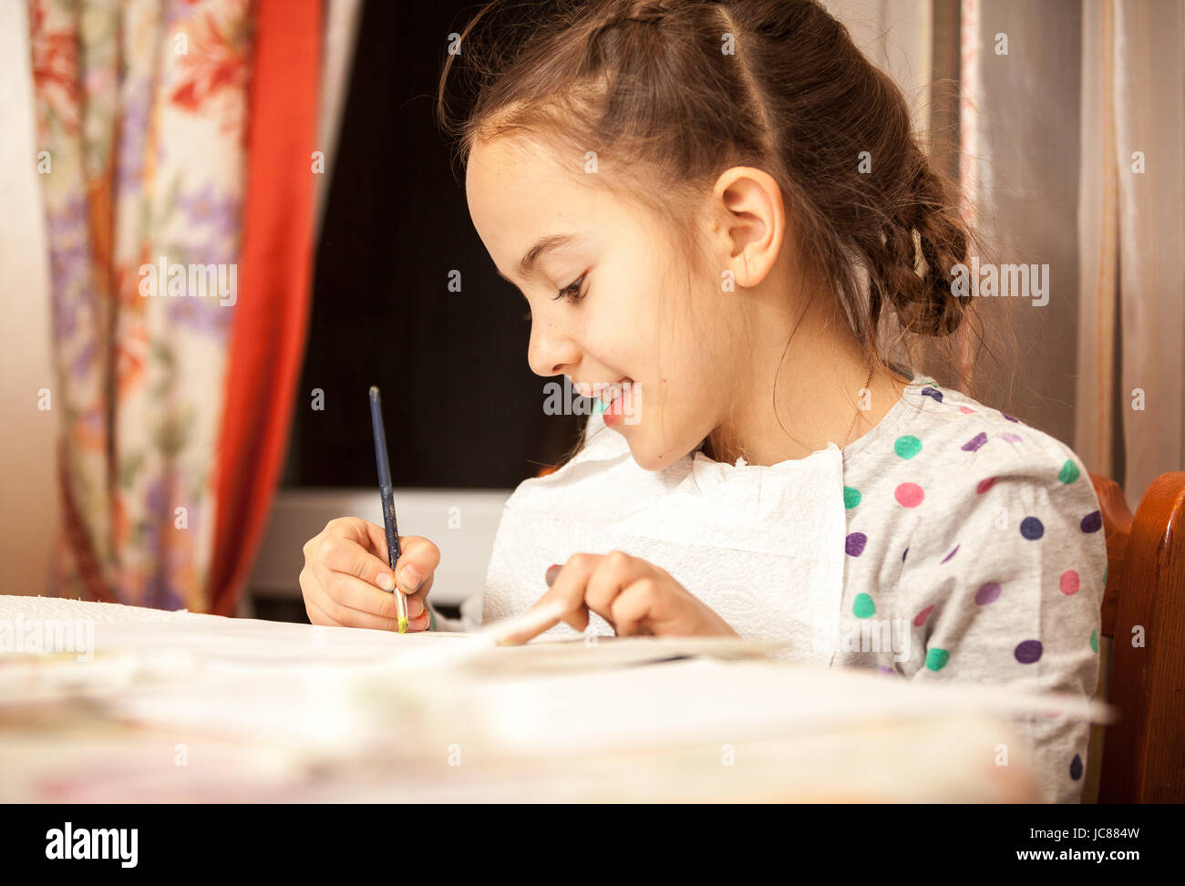 Portrait of diligent girl doing drawings with brush Stock Photo - Alamy
