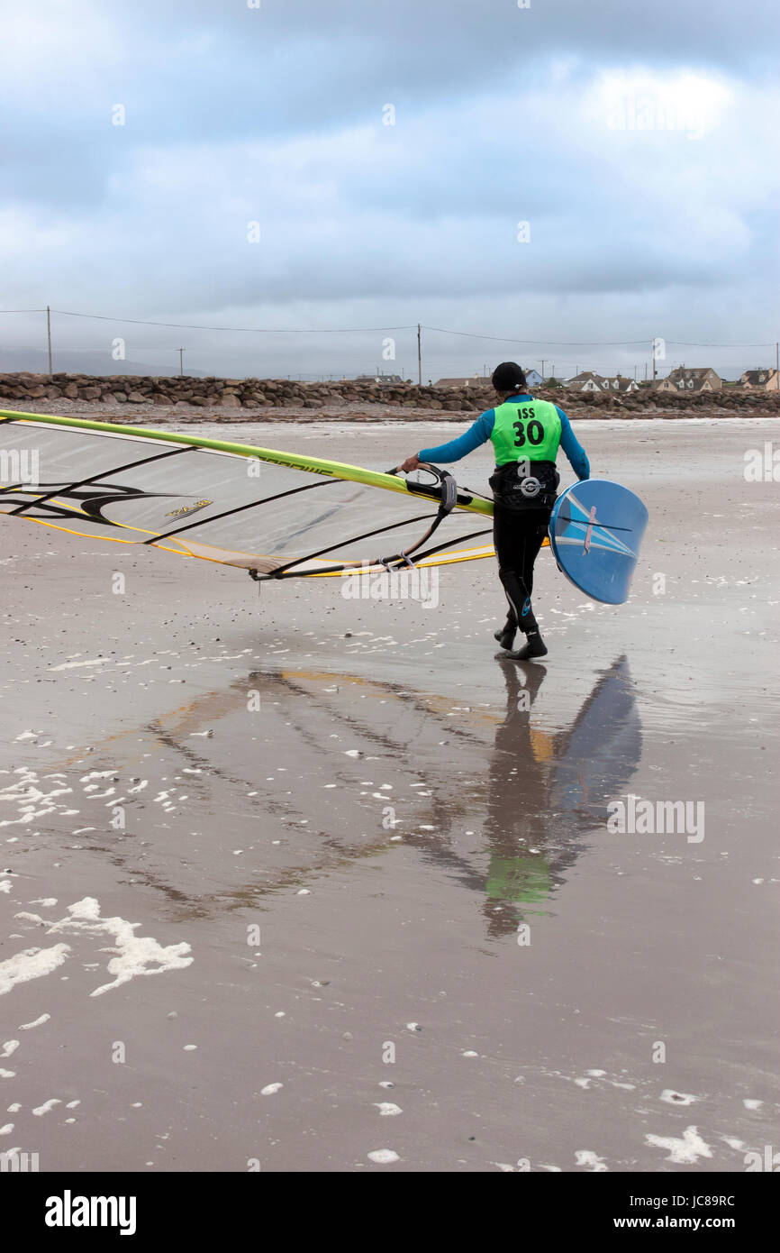 windsurfer finishing up after race and surf on the beach in the ...