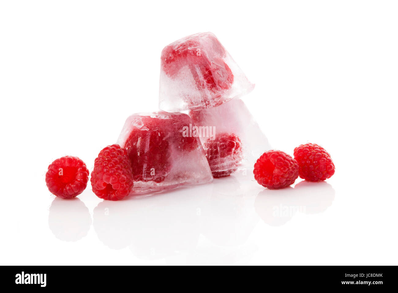 Ripe fresh raspberries frozen in ice cubes isolated on white background ...