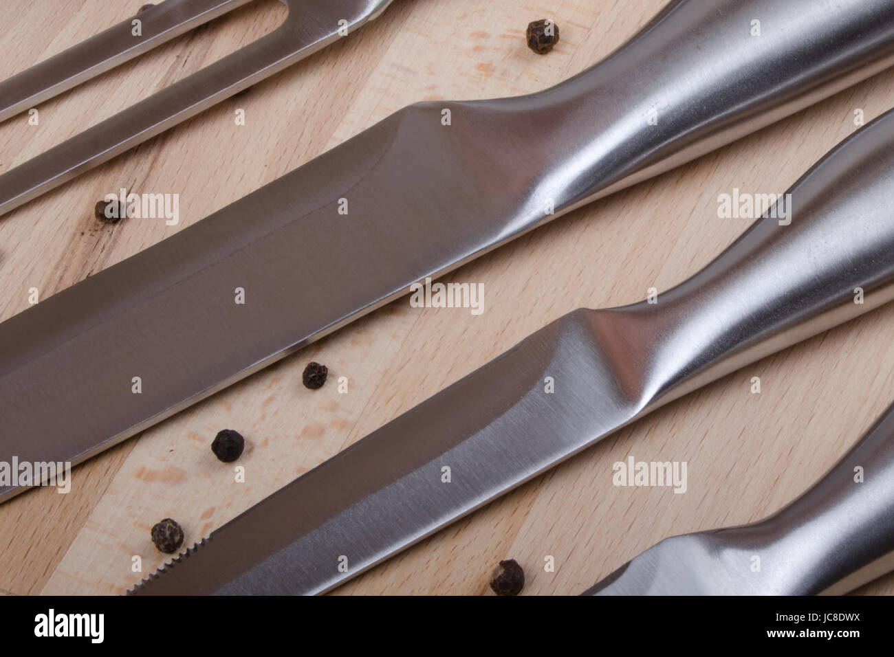 metallic sharp kitchen instruments on cuting board made of wood Stock ...