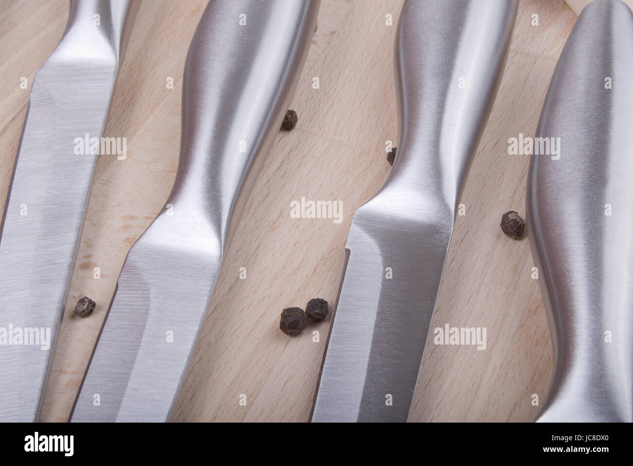 metallic sharp kitchen instruments on cuting board made of wood Stock ...