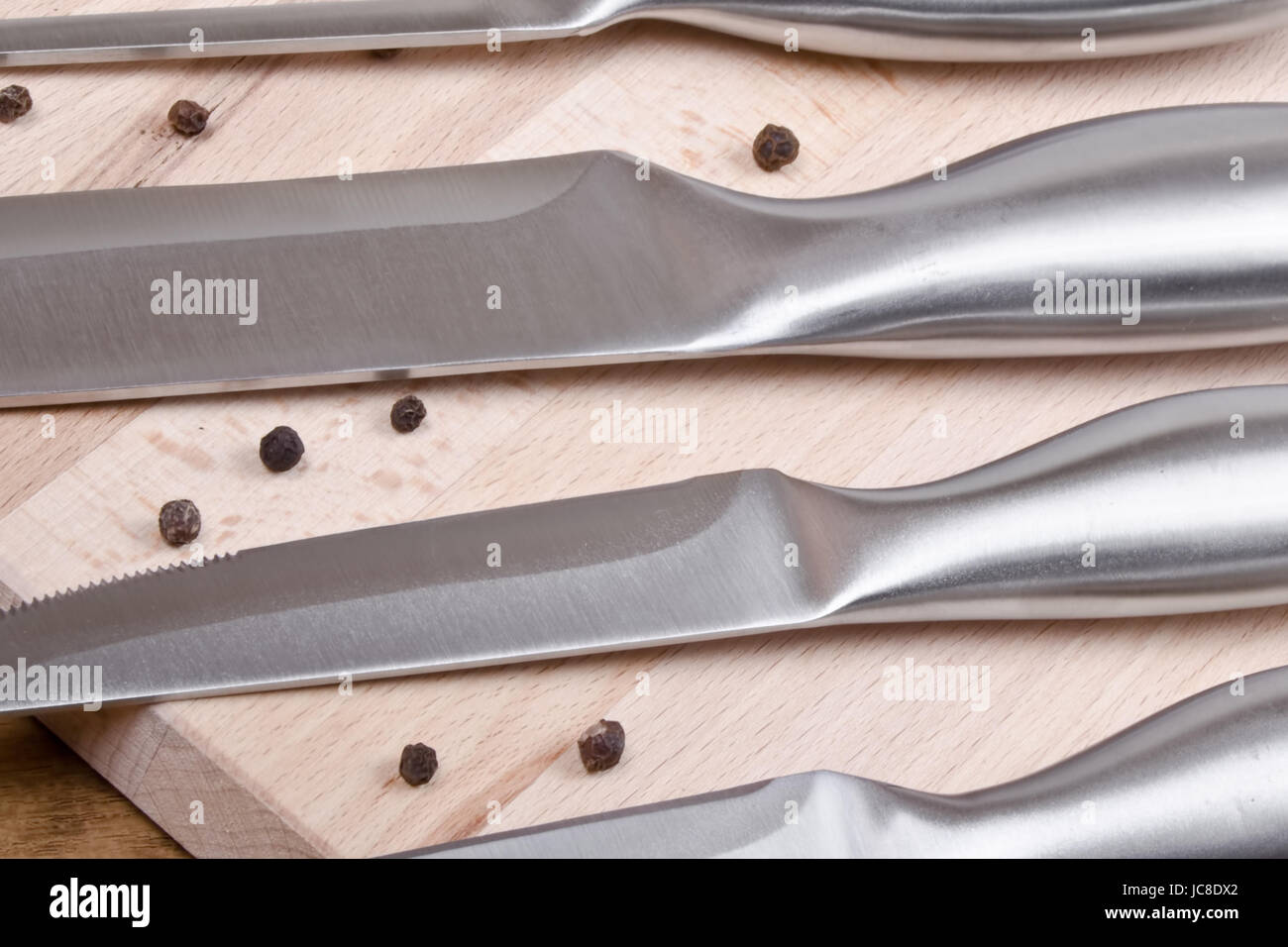 metallic sharp kitchen instruments on cuting board made of wood Stock ...