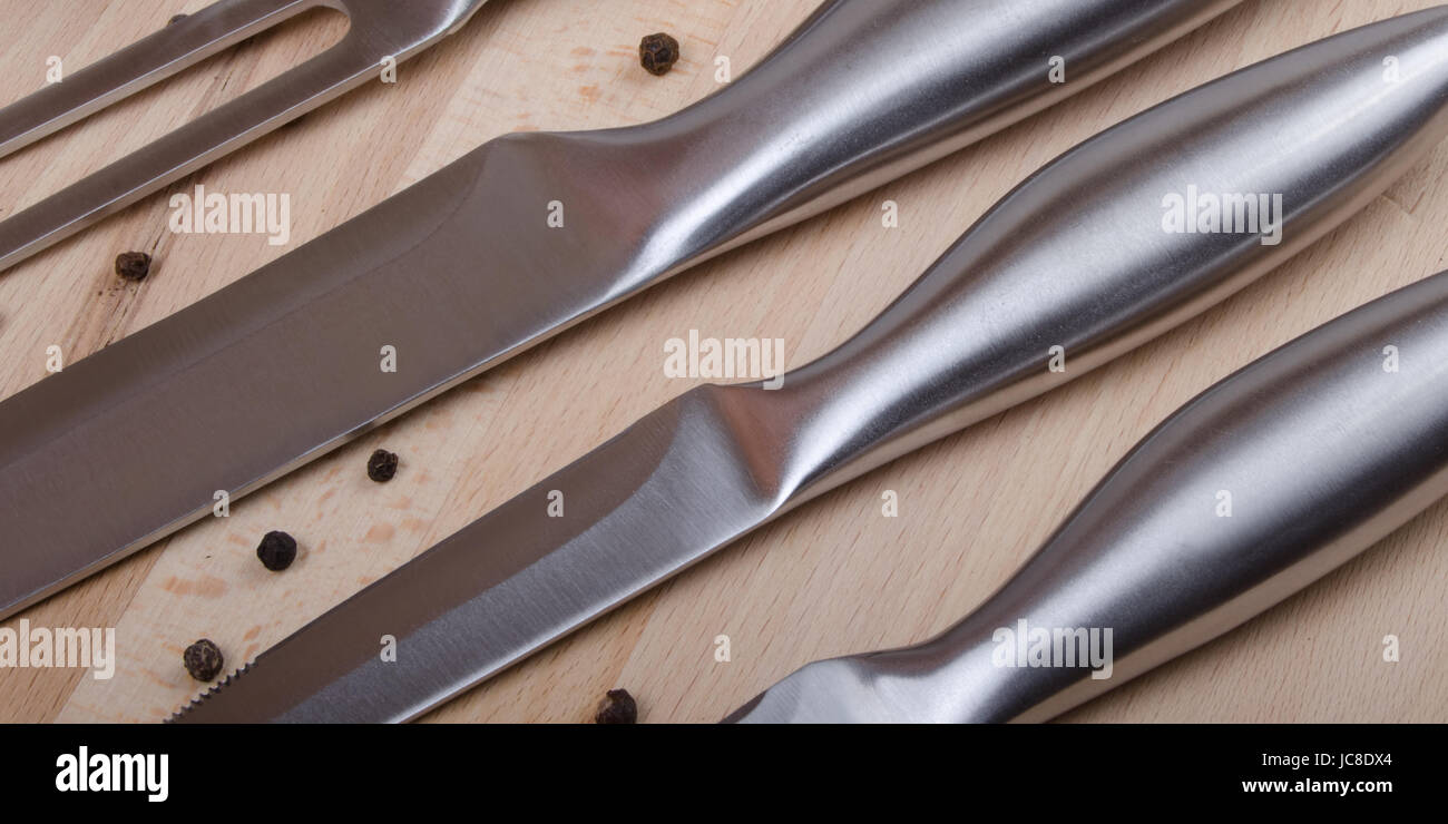metallic sharp kitchen instruments on cuting board made of wood Stock ...