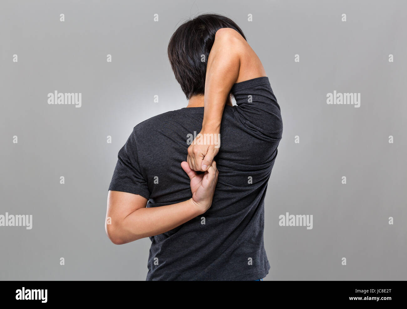 Man stretching arm behind back Stock Photo - Alamy
