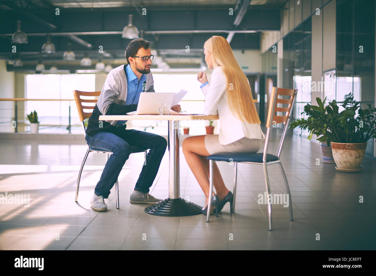 Two business people looking through papers at meeting Stock Photo - Alamy