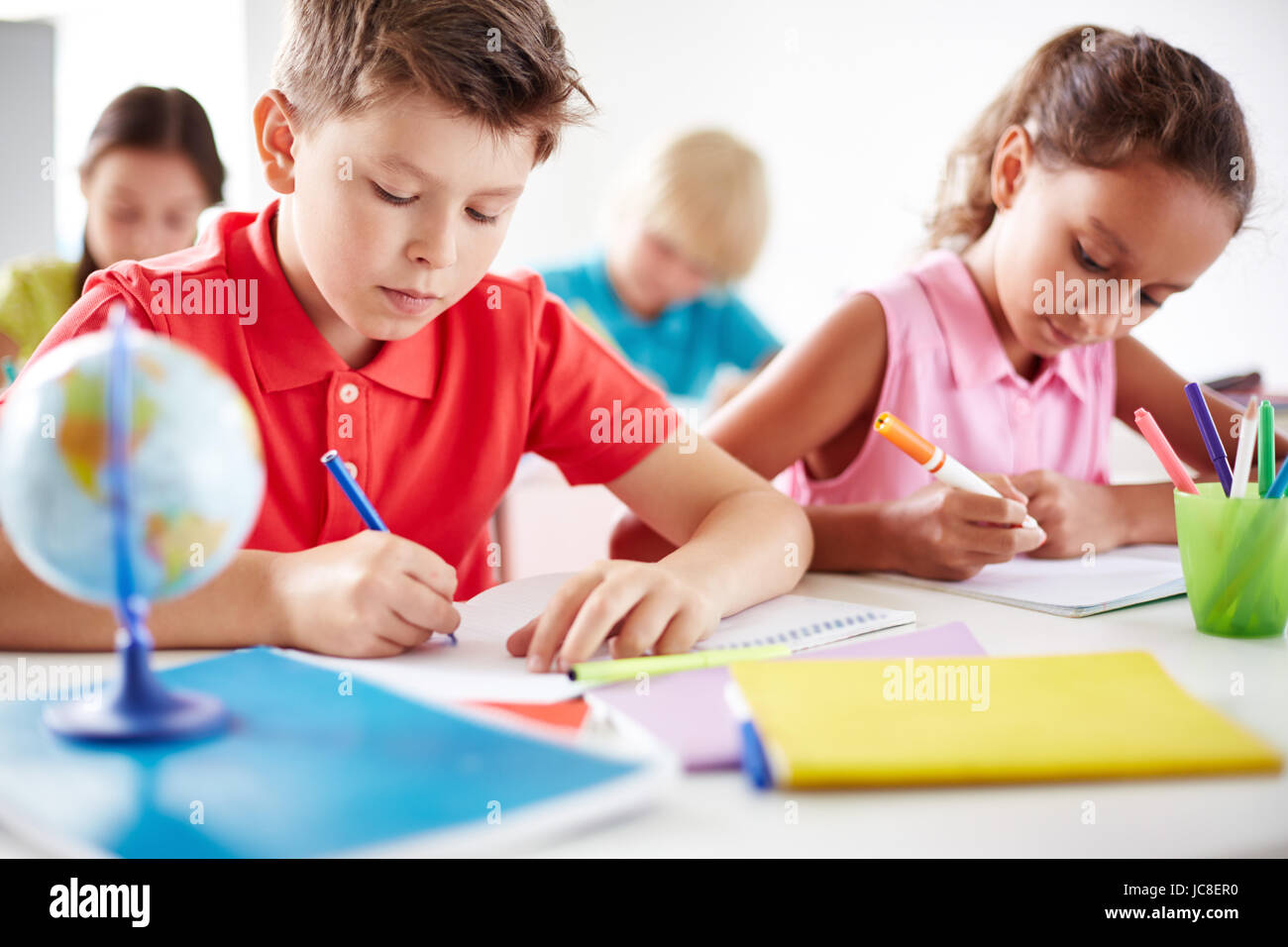 Junior pupils drawing with multi-color highlighters at lesson Stock ...