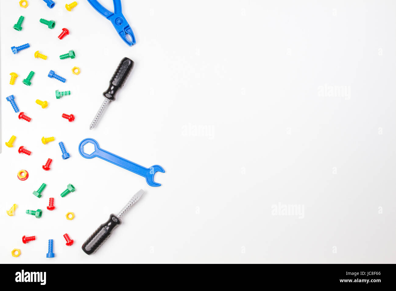 Colorful kids toys border. Plastic toy tools, bolts and nuts on white ...