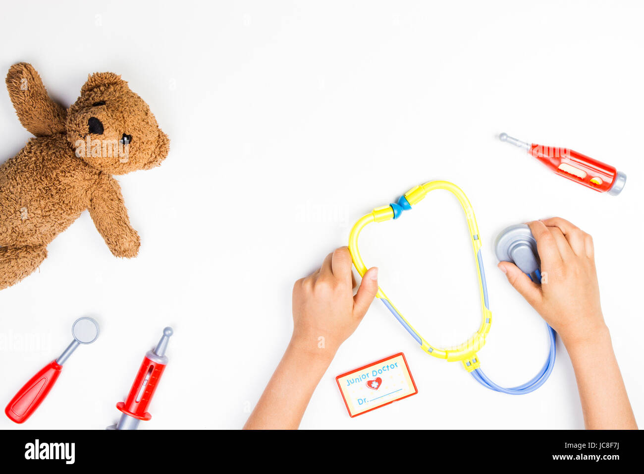 Junior doctor. Kid hands with toy stethoscope, teddy bear and toy ...