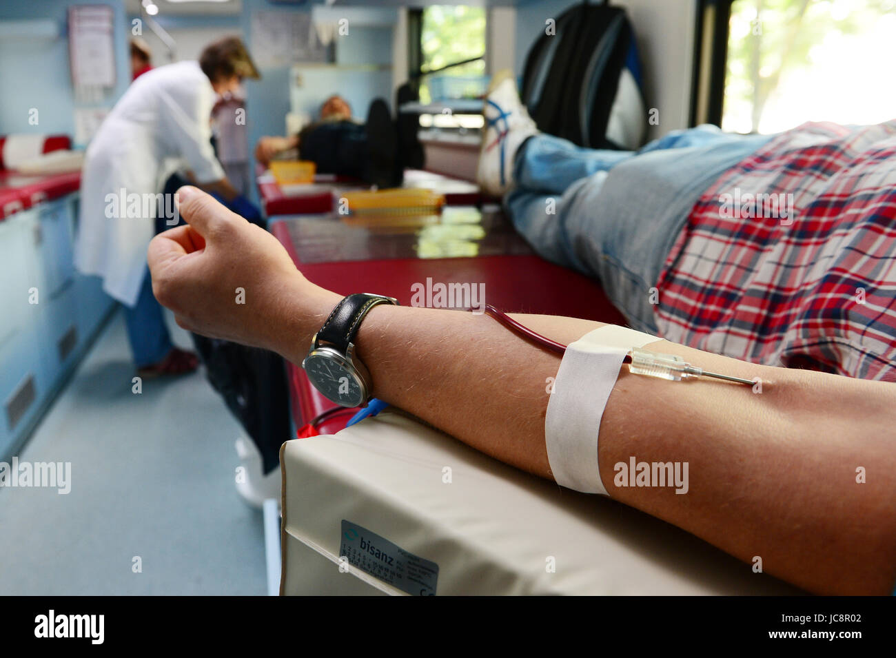 A blood donor lies at the German Red Cross Blood Donation and has blood ...