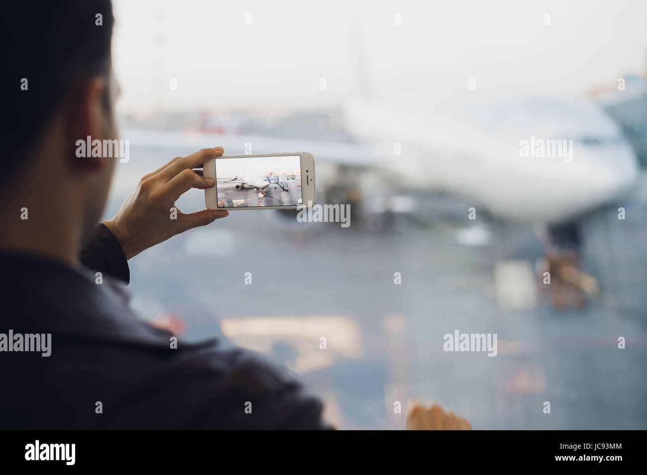 traveler with mobile phone at the airport taking picture of his ...