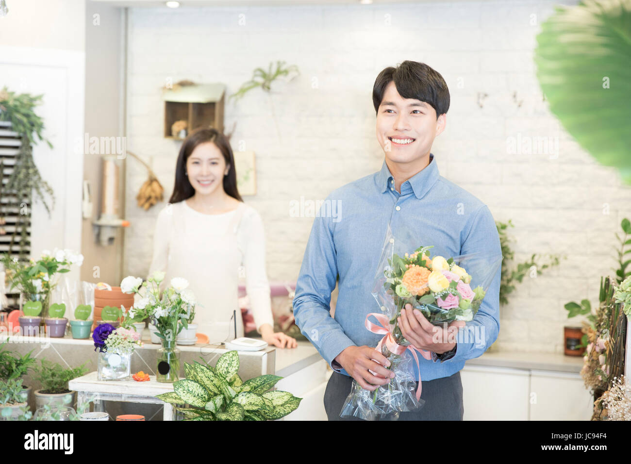 Smiling florist and customer with flowers at shop Stock Photo - Alamy