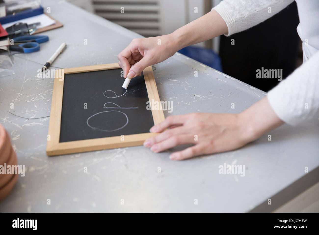 Woman writing on board with chalk Stock Photo - Alamy