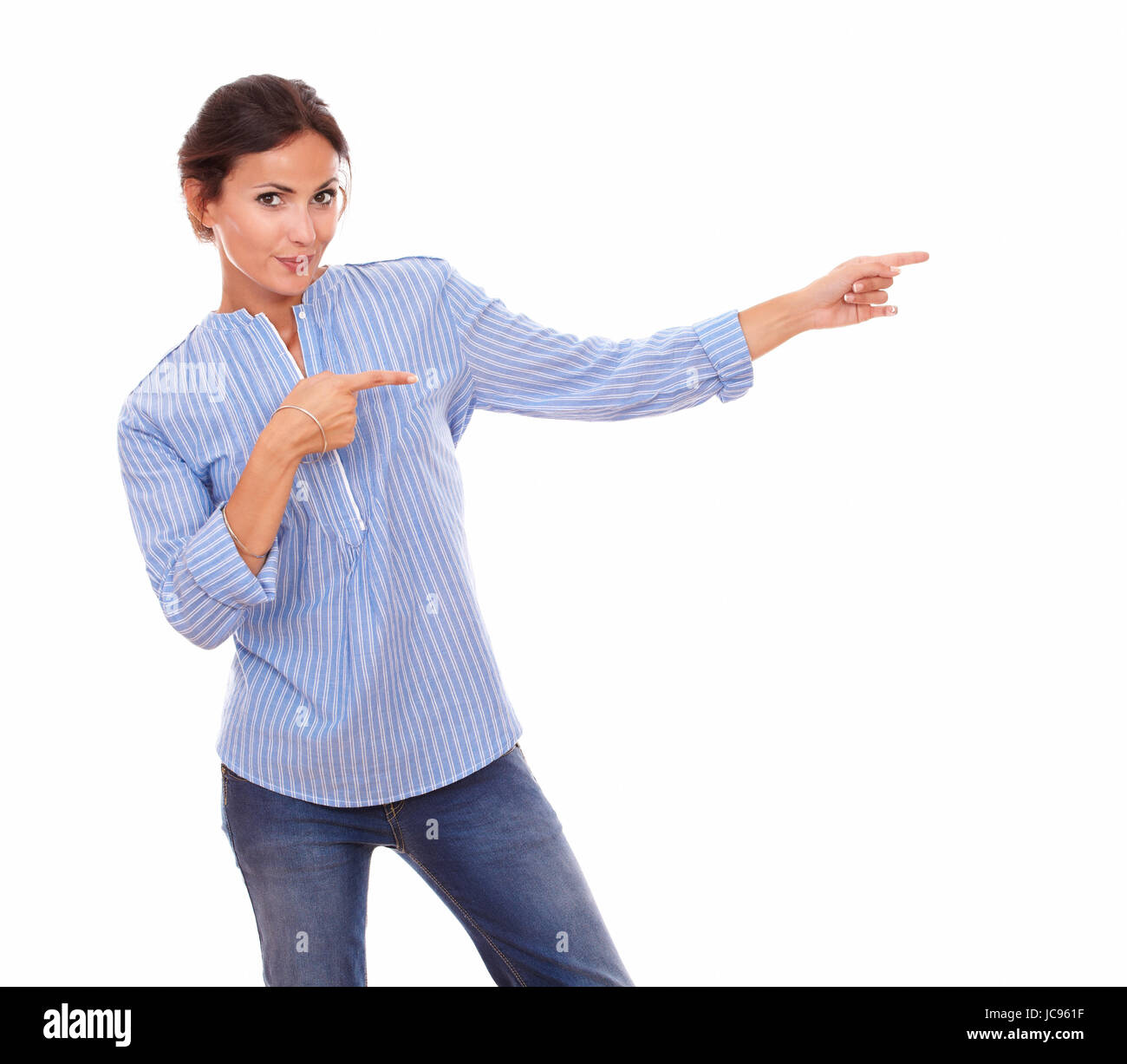 Portrait of lovely woman pointing to her left while standing and ...