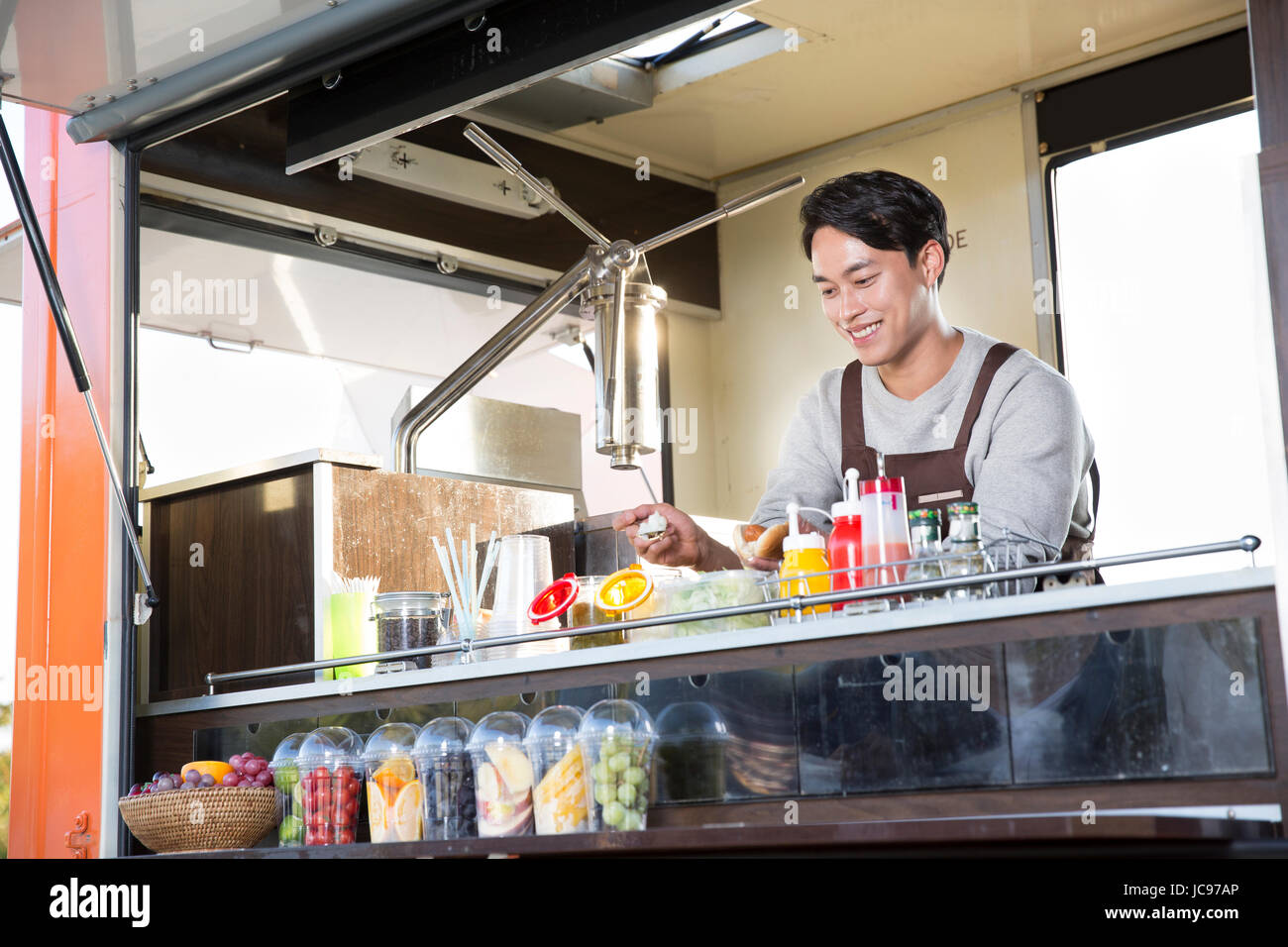 Young smiling vendor at food truck Stock Photo - Alamy