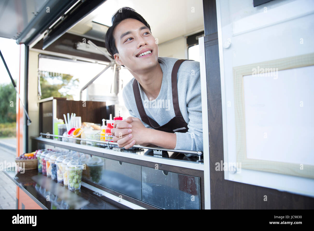 Portrait of young smiling vendor at food truck Stock Photo - Alamy