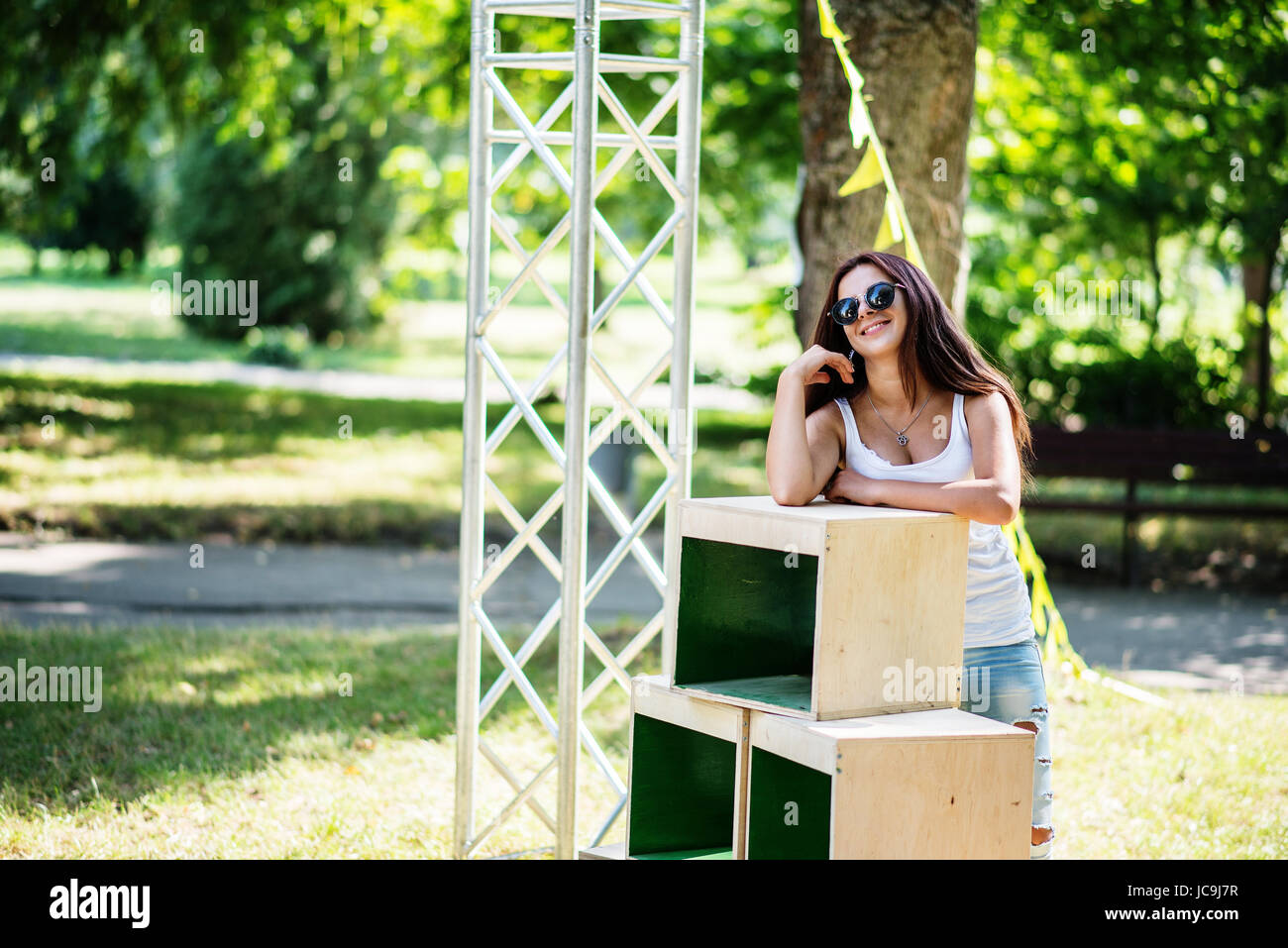 Portrait of a fashionably dressed girl posing on wooden boxes in the ...