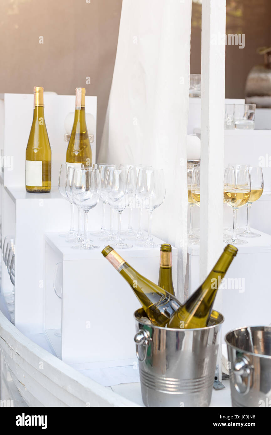 Bottles of white wine standing on serving table. Outdoor party ...