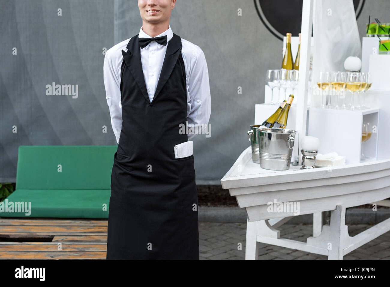 Midsection of professional waiter in uniform serving wine during buffet ...