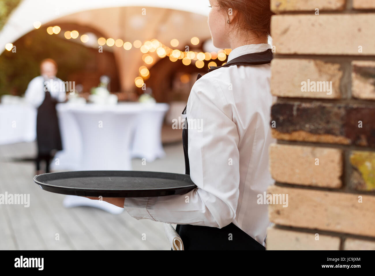Waiter holding an empty tray in outdoor cafe. Catering service Stock ...