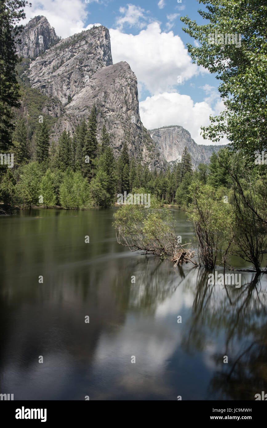 A long exposure smoothes the water of the Merced River, while the Three ...
