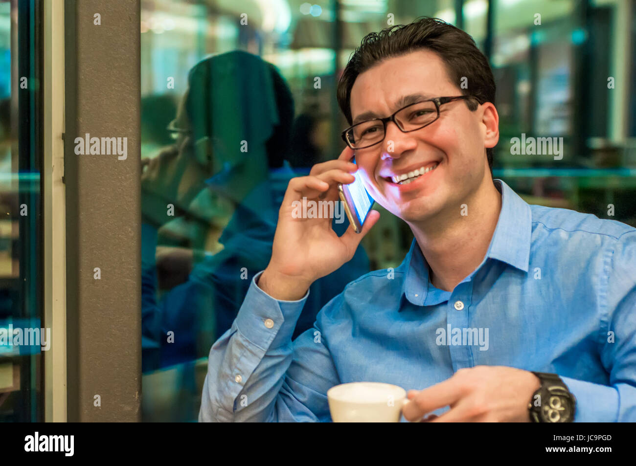 Authentic image of a businessman working in a cafe. Man talking on the ...