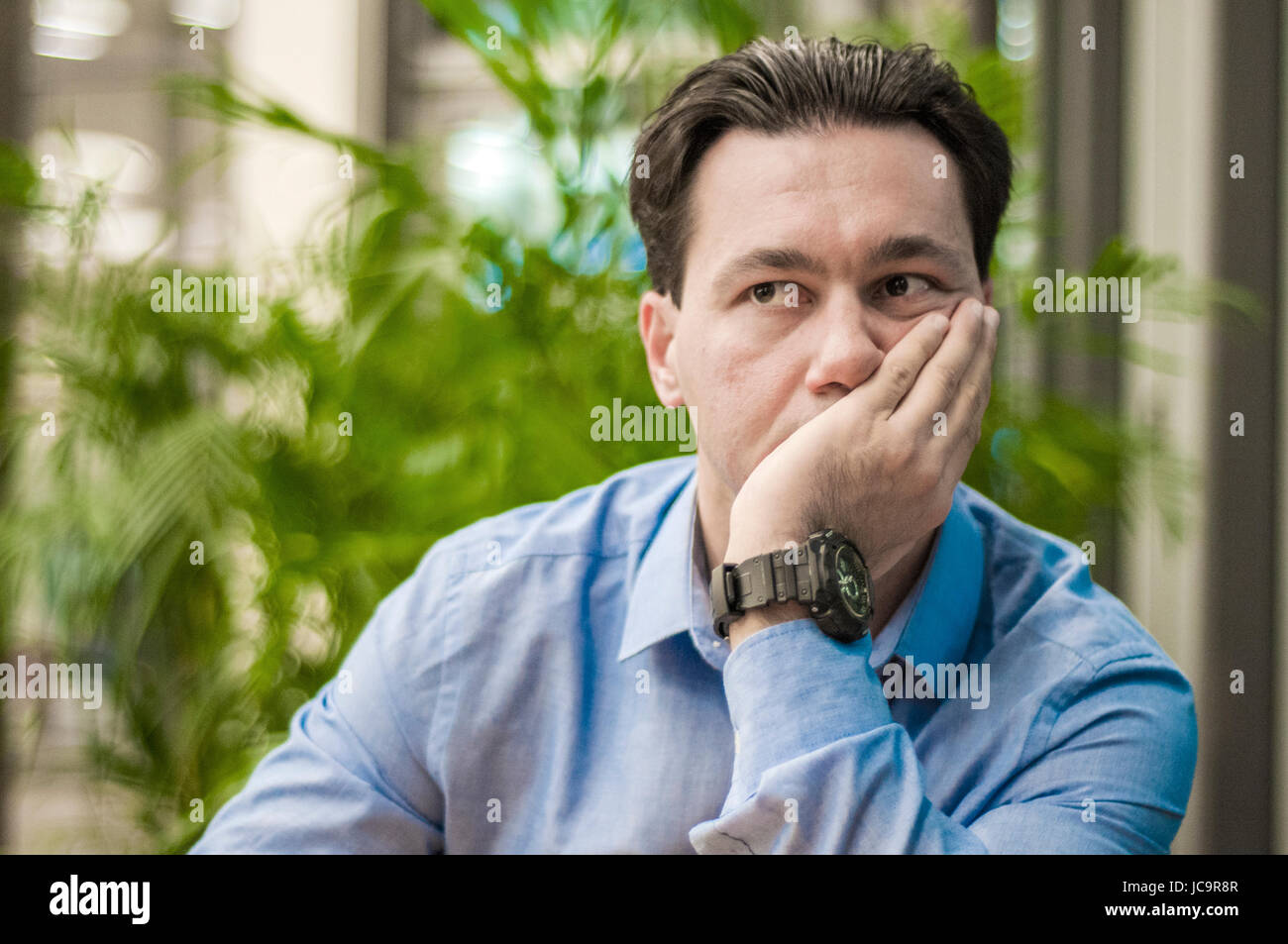 Feeling sick and tired. Frustrated young man keeping eyes closed while ...