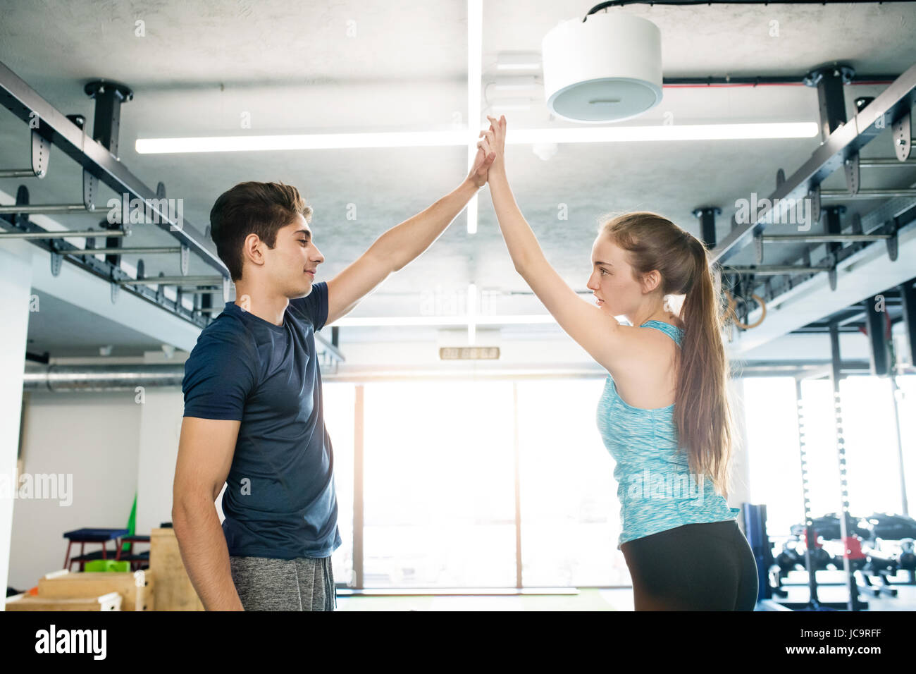 Young fit couple exercising in gym, giving high five each other Stock ...