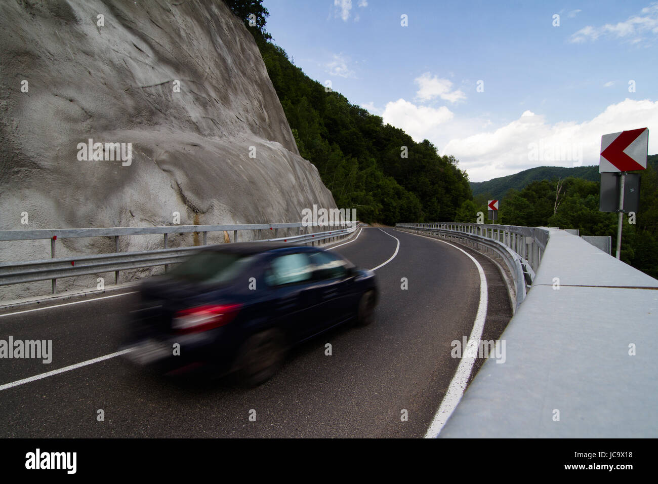 horizontal rear view of a black car with motion blur on a steep asphalt ...