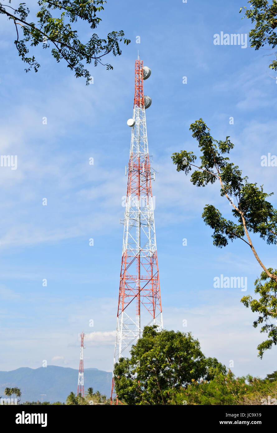 Tower relay signal and tree on blue sky background Stock Photo - Alamy