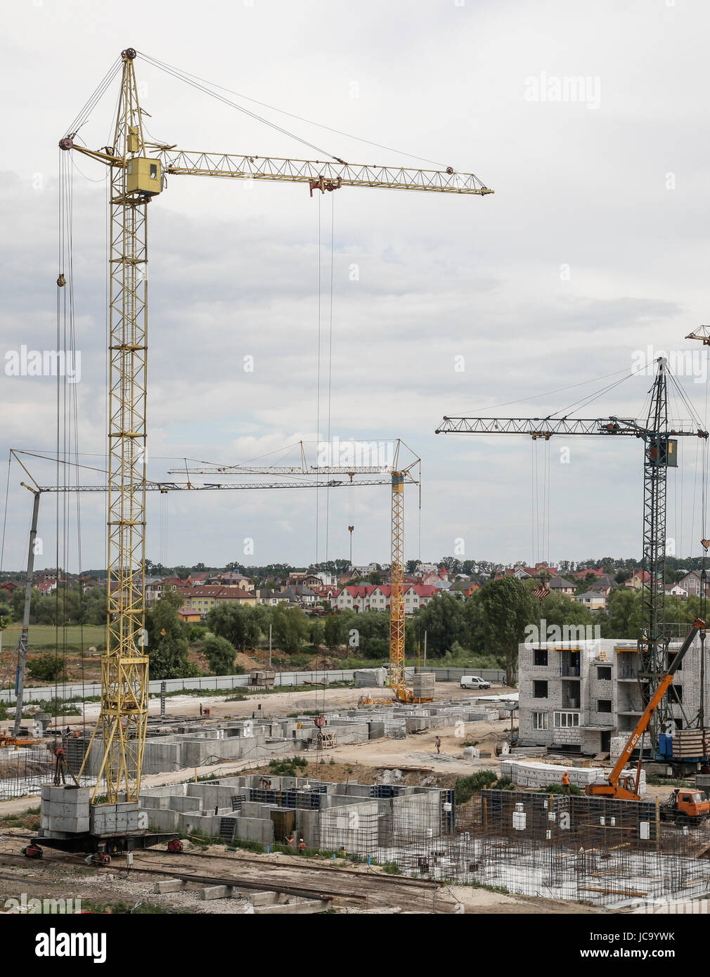 Construction workers and the machinery are seen at a construction site ...