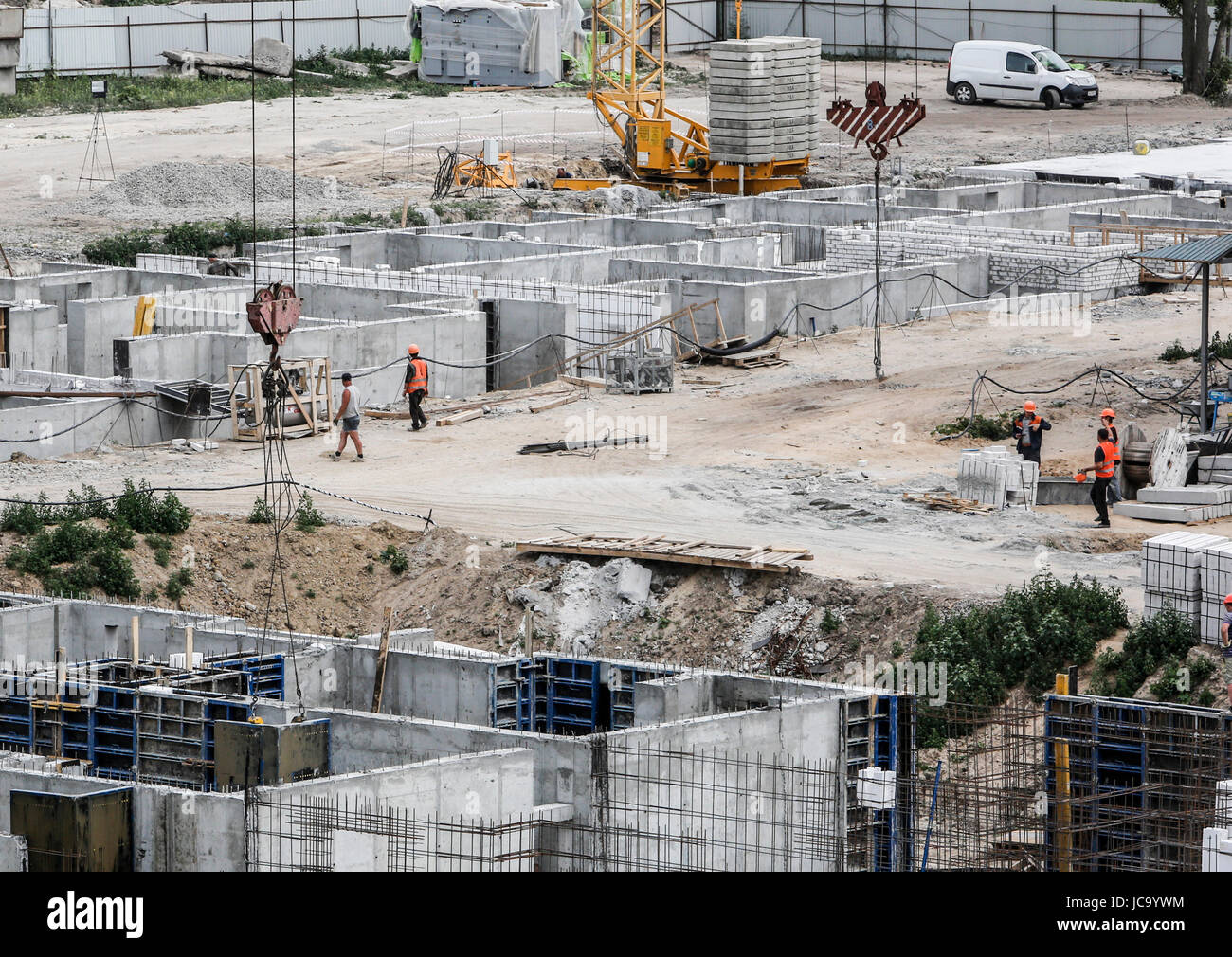 Construction workers and the machinery are seen at a construction site ...