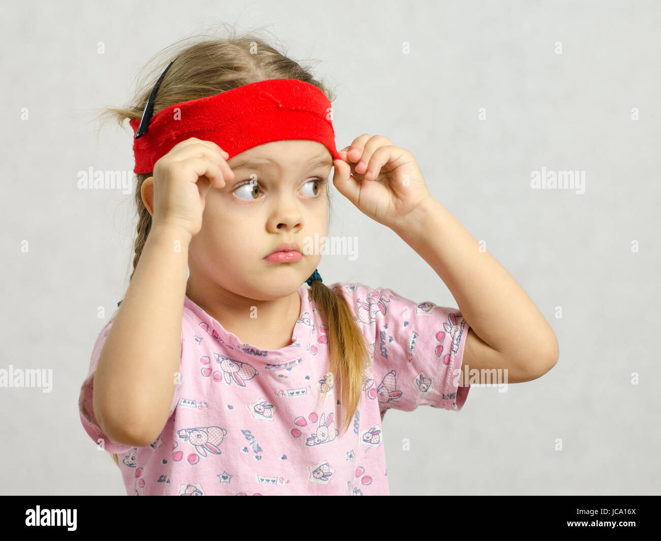 Girl with a bandage on his head stares right. Trying to cover his eyes ...