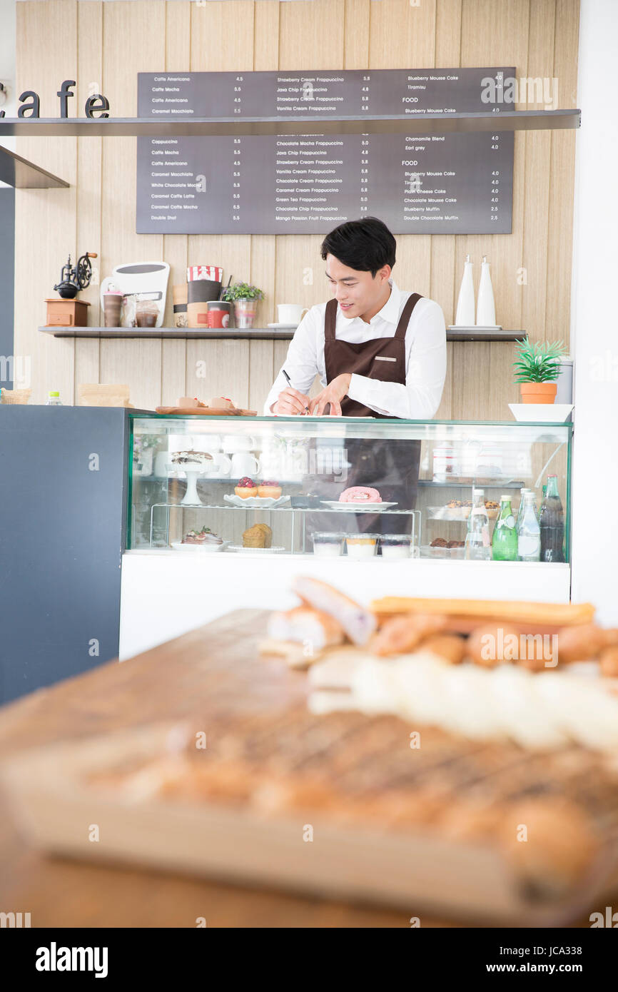 Young smiling man working at bakery Stock Photo - Alamy